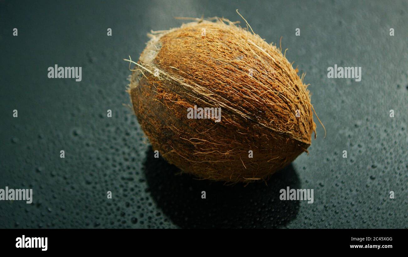 Whole unpeeled coconut Stock Photo - Alamy