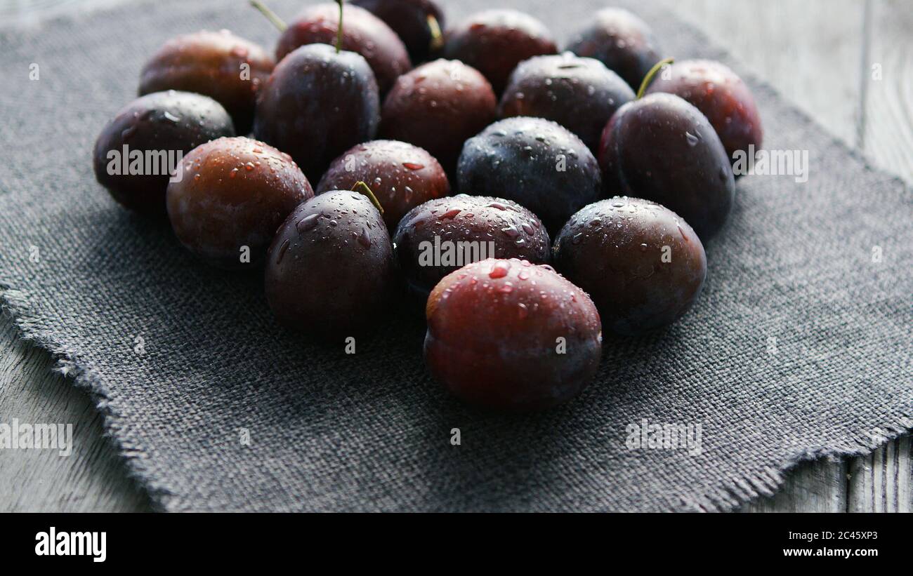 Wet fresh plums on napkin Stock Photo - Alamy