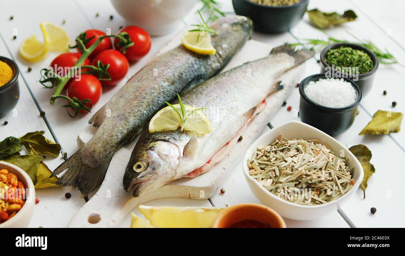 Spices and tomatoes around fish Stock Photo - Alamy