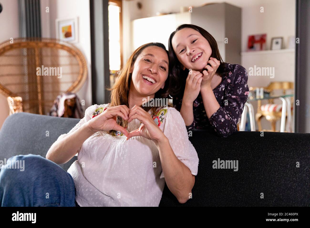 Mother and daughter making heart gesture, online celebration during ...