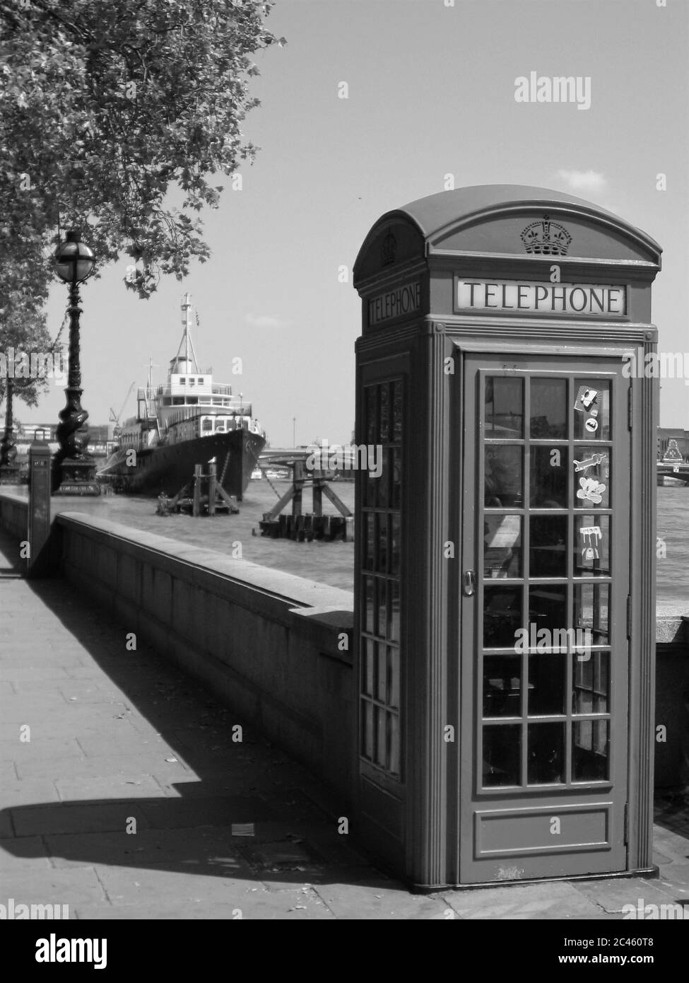 London phone box on Embankment with ship Stock Photo - Alamy