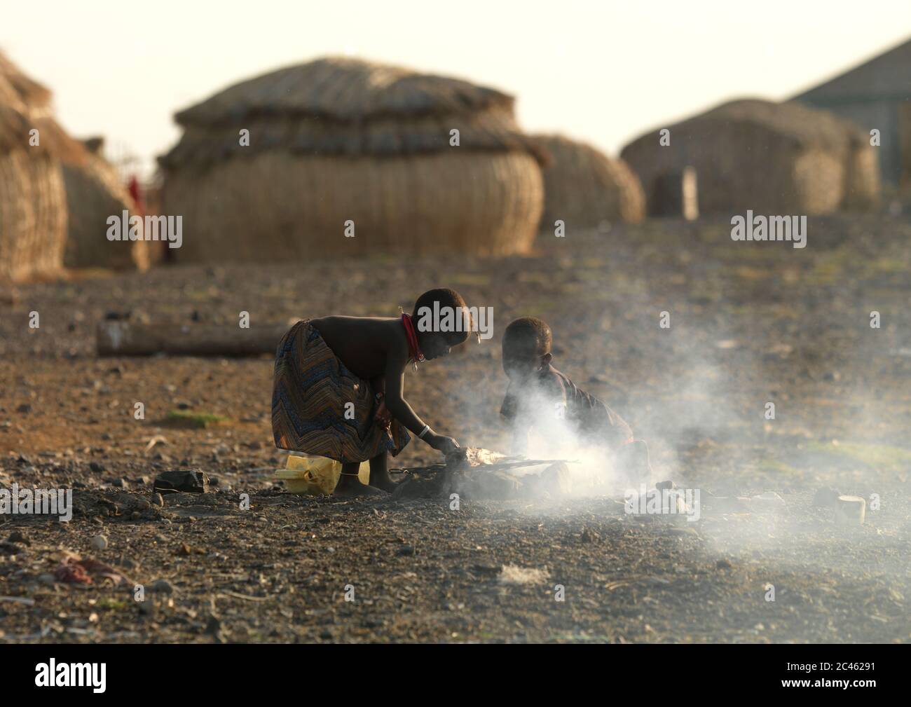 Grass huts and children making fire in el molo tribe village, Turkana ...