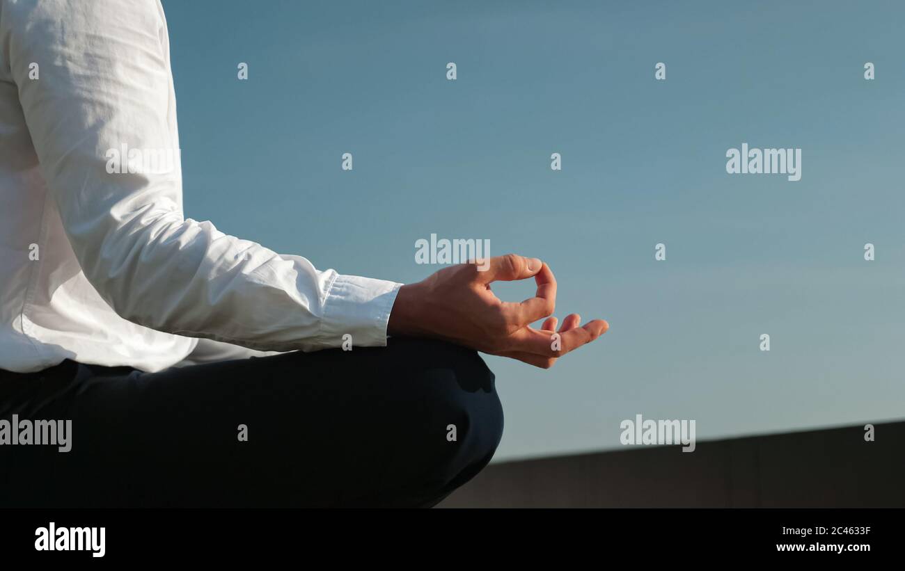 Man in blue shirt meditates hi-res stock photography and images - Alamy