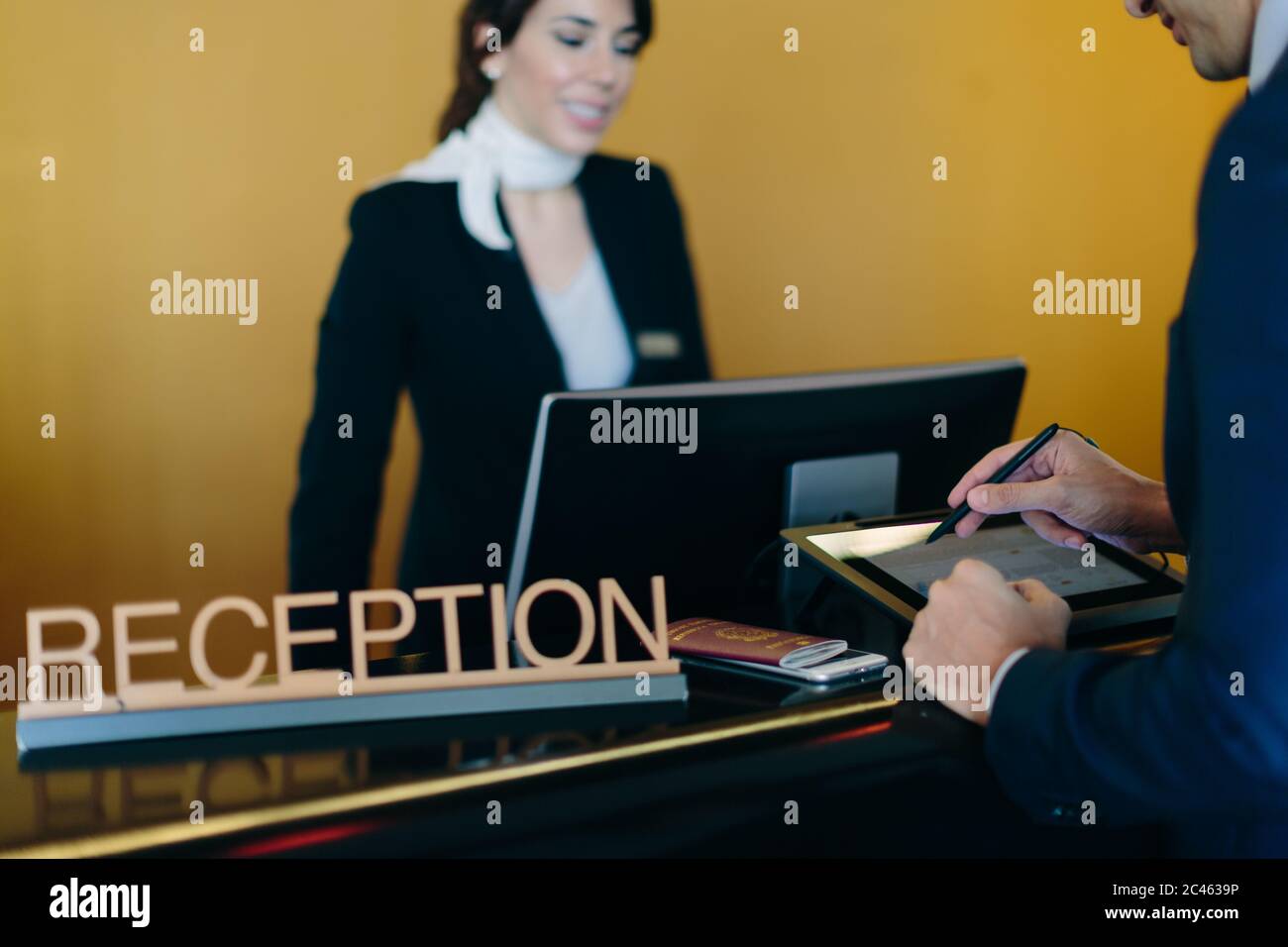 Businessman checking in at hotel reception Stock Photo - Alamy
