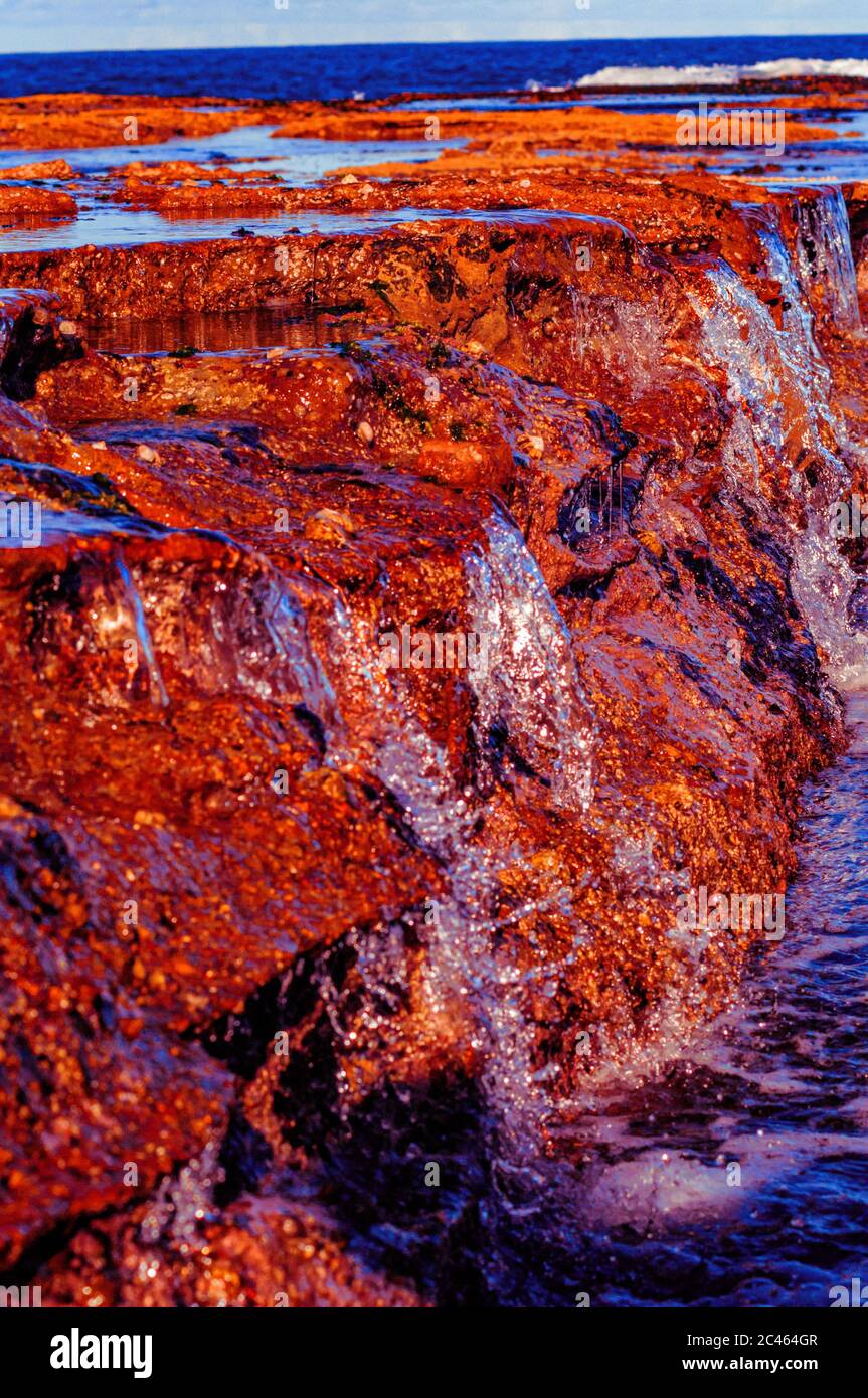 Water pouring through the rock formations in the sea Stock Photo - Alamy
