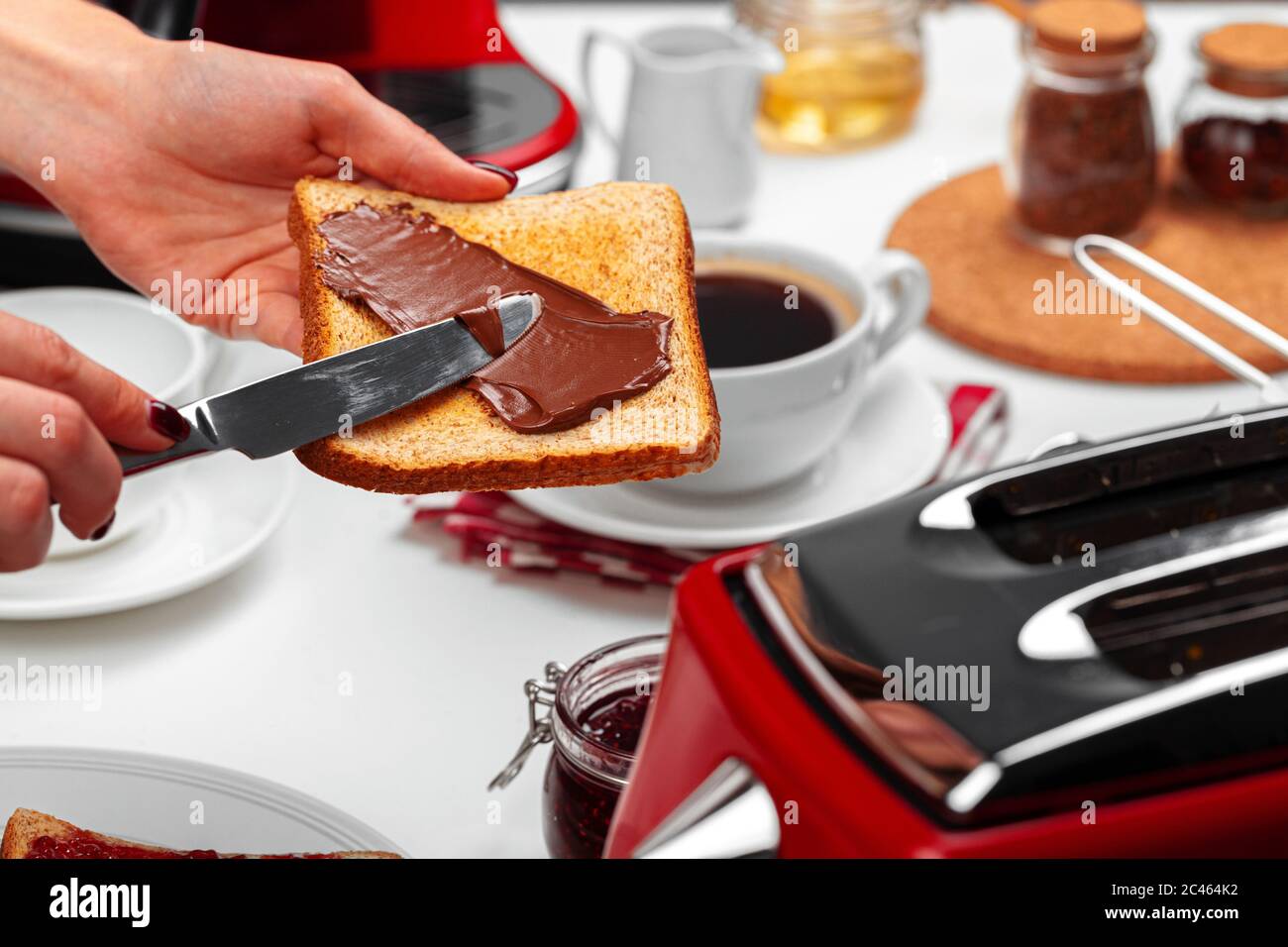 Female hand cooking toast with chocolate paste Stock Photo - Alamy