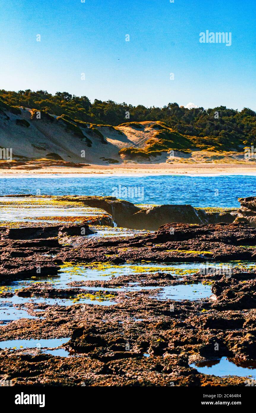 Rock formations in the sea with the coast in the background Stock Photo ...