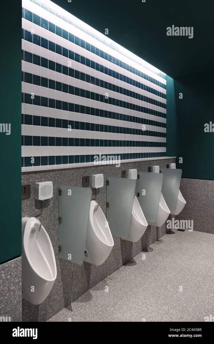 Urinals in a stylish toilet with dark green walls Stock Photo - Alamy