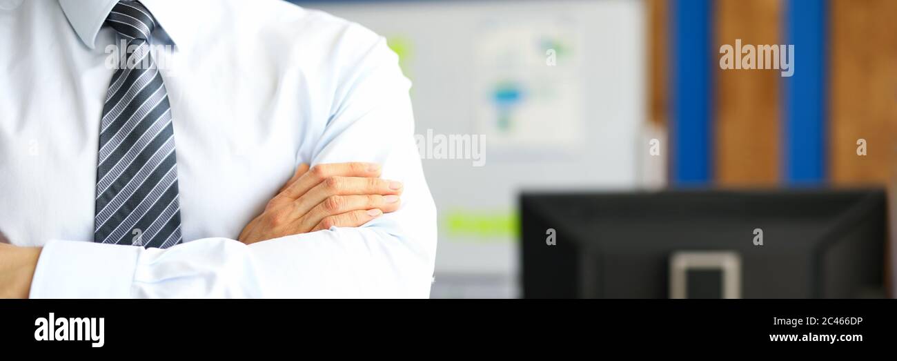 Boss standing in an office with his arms crossed Stock Photo - Alamy