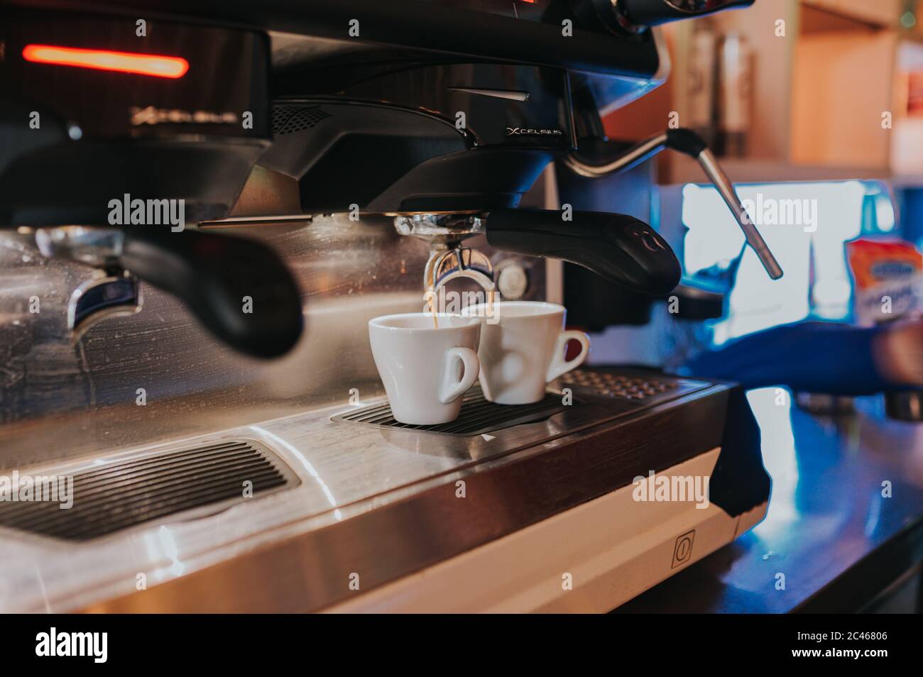 White little cups put under the coffee machine filling with coffee ...