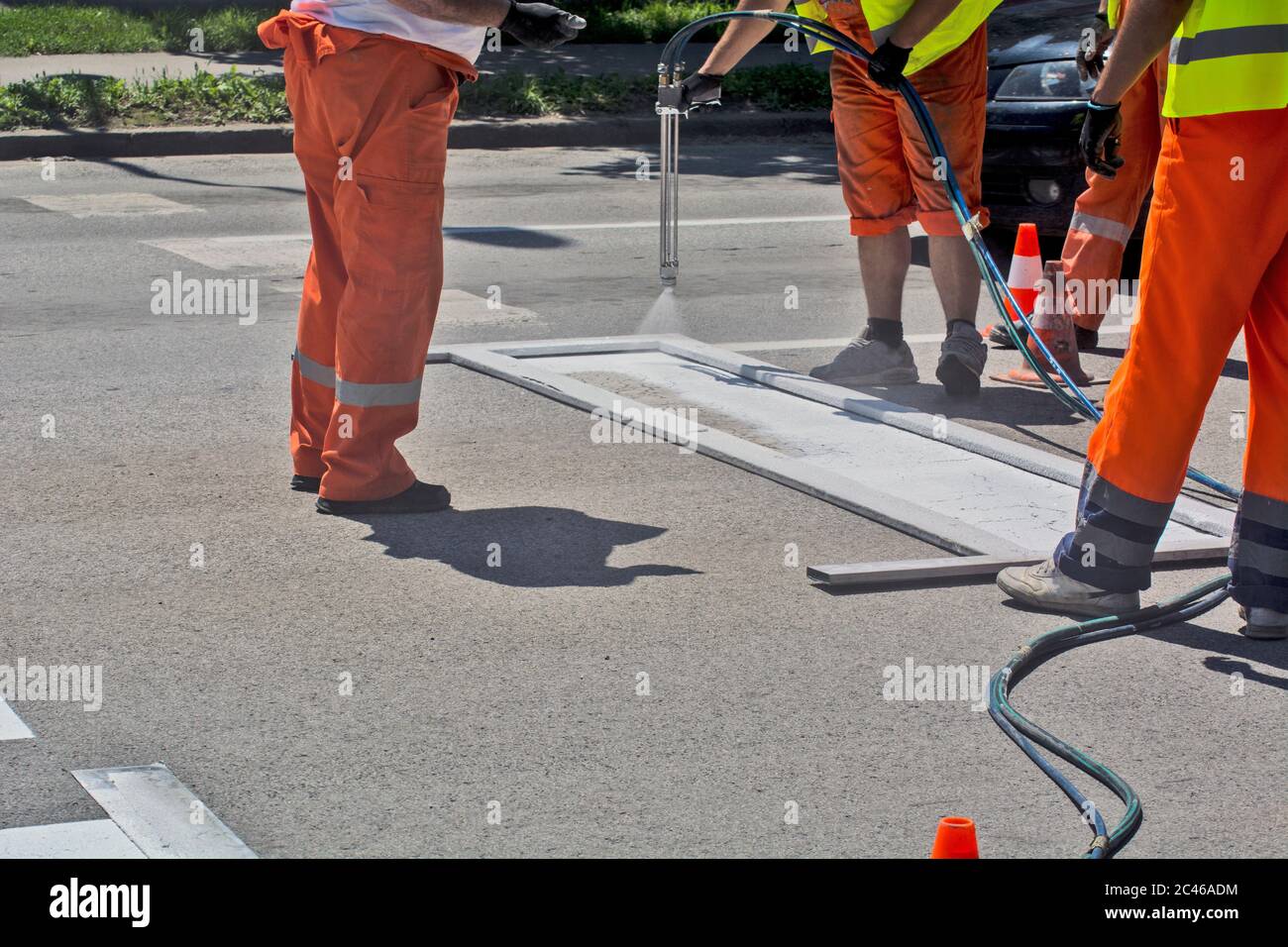 Workers are painting a stop line in a city street Stock Photo - Alamy