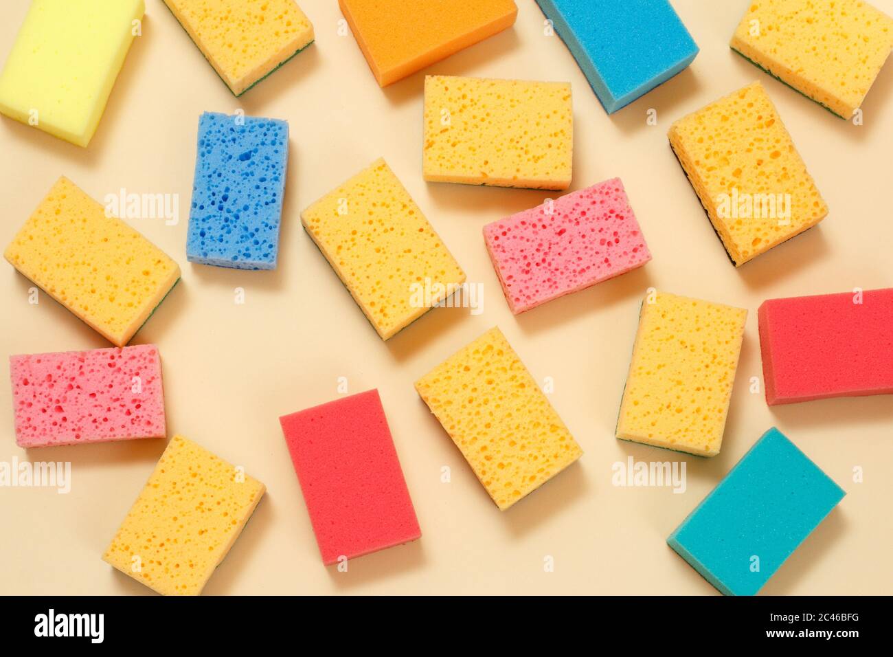 Sponges of different colors on a beige background. Top view. Washing ...