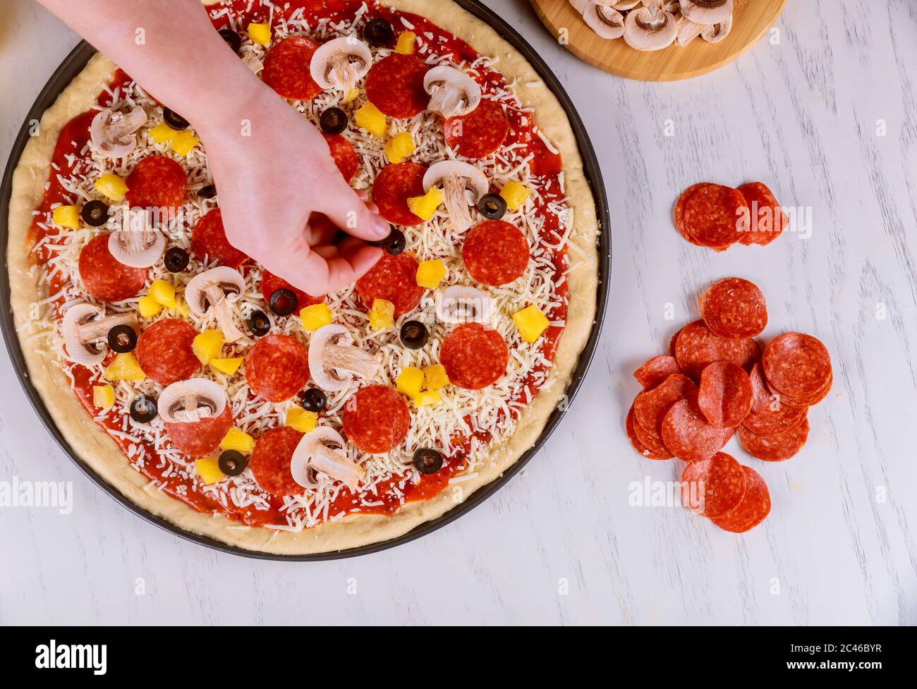 Chef putting pepperoni on pizza hi-res stock photography and images - Alamy