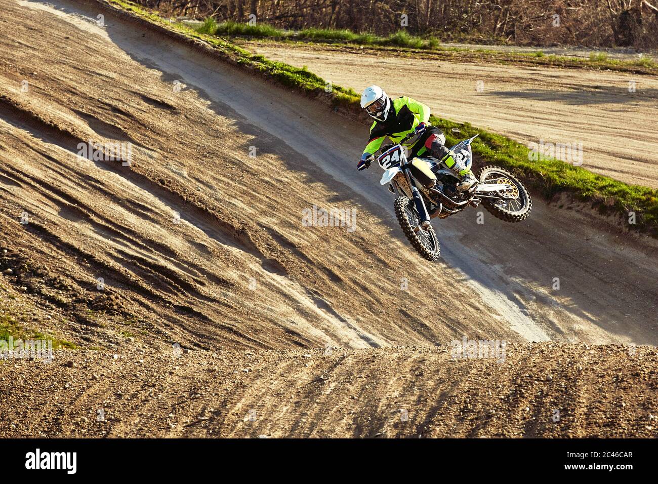 Motocross driver in action accelerating the motorbike takes off and ...