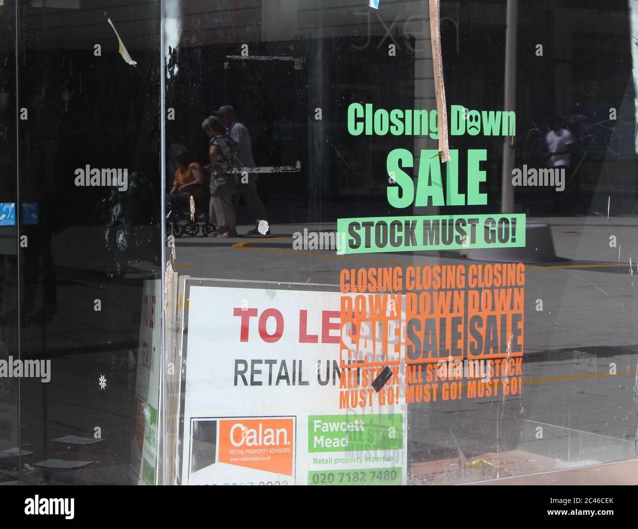 A photograph of a shop windows which has closed down. 'To let' sign ...