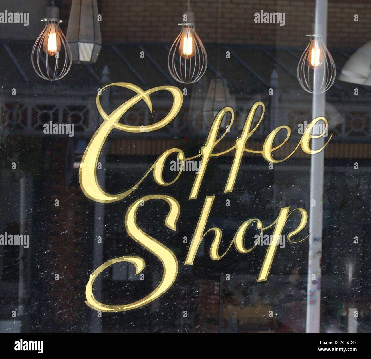 A photograph of a hand-painted 'Coffee Shop' window sign on a dirty ...