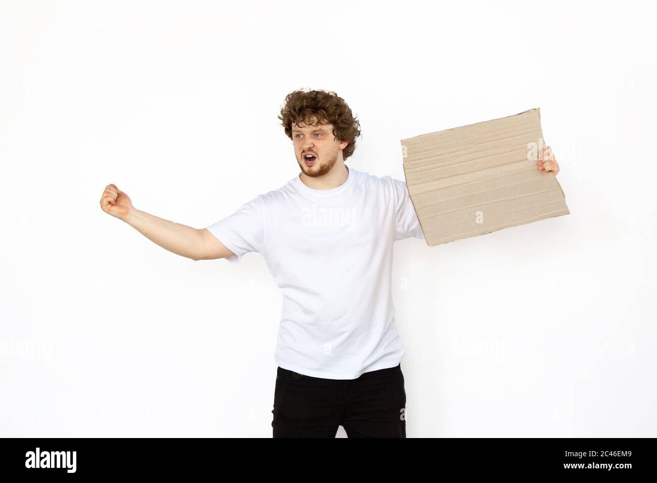 Young man protesting with blank board, sign isolated on white studio ...