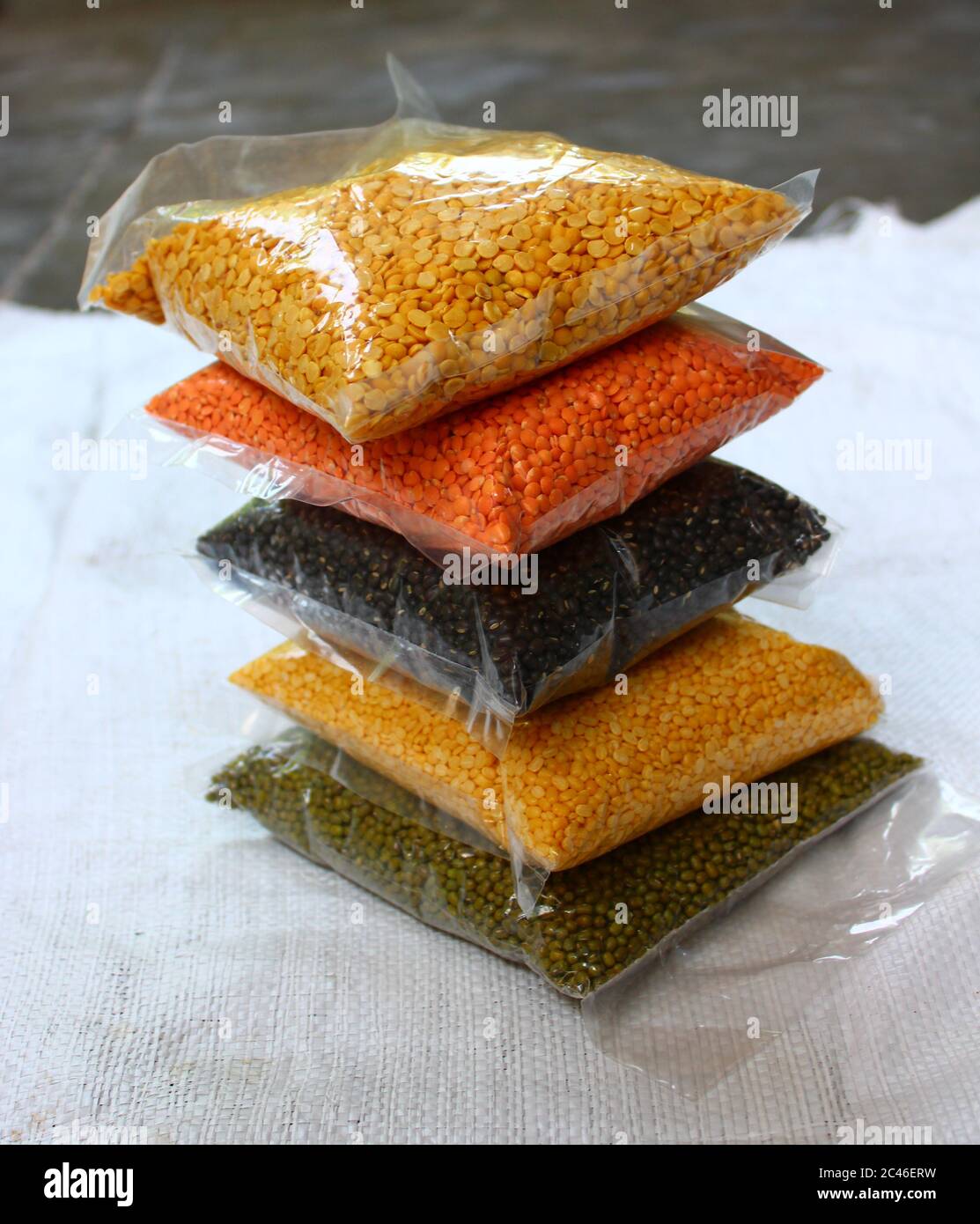 Stack of colorful lentils packed inside transparent plastic packets ...