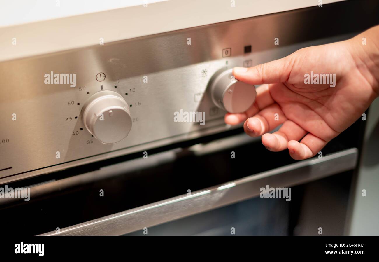 Close up female hand Opening Or Closing modern electric oven prepare to ...