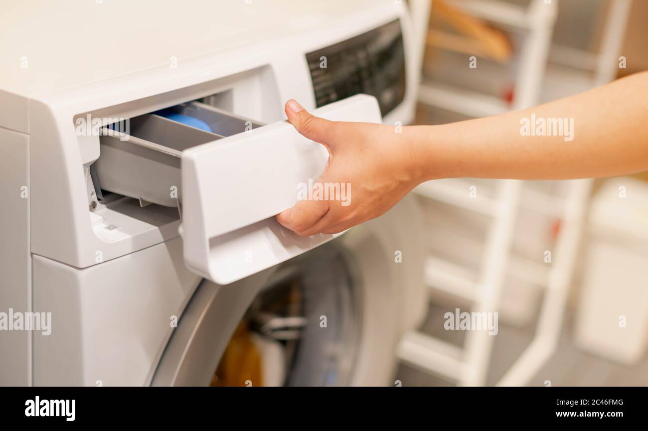 Female hand opening the washing machine and the space for detergent ...