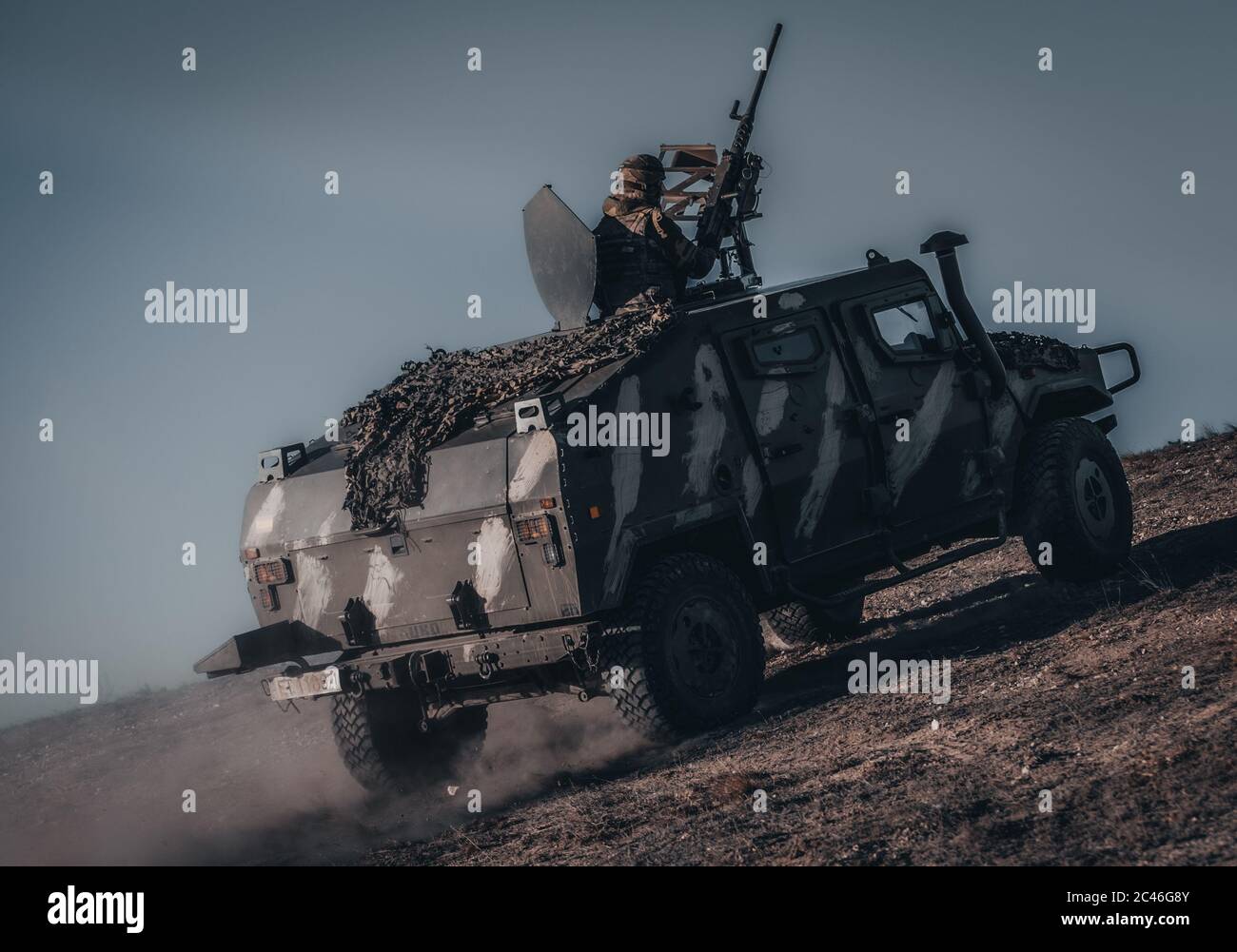 Dutch angle shot of a military vehicle with a mounted machine gun and ...