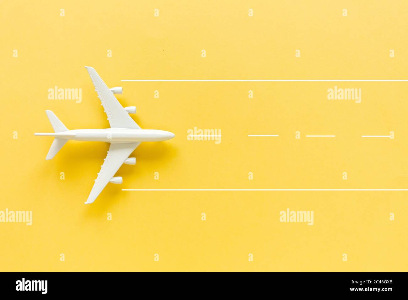 White model plane, airplane on yellow background. Top view, flat lay ...