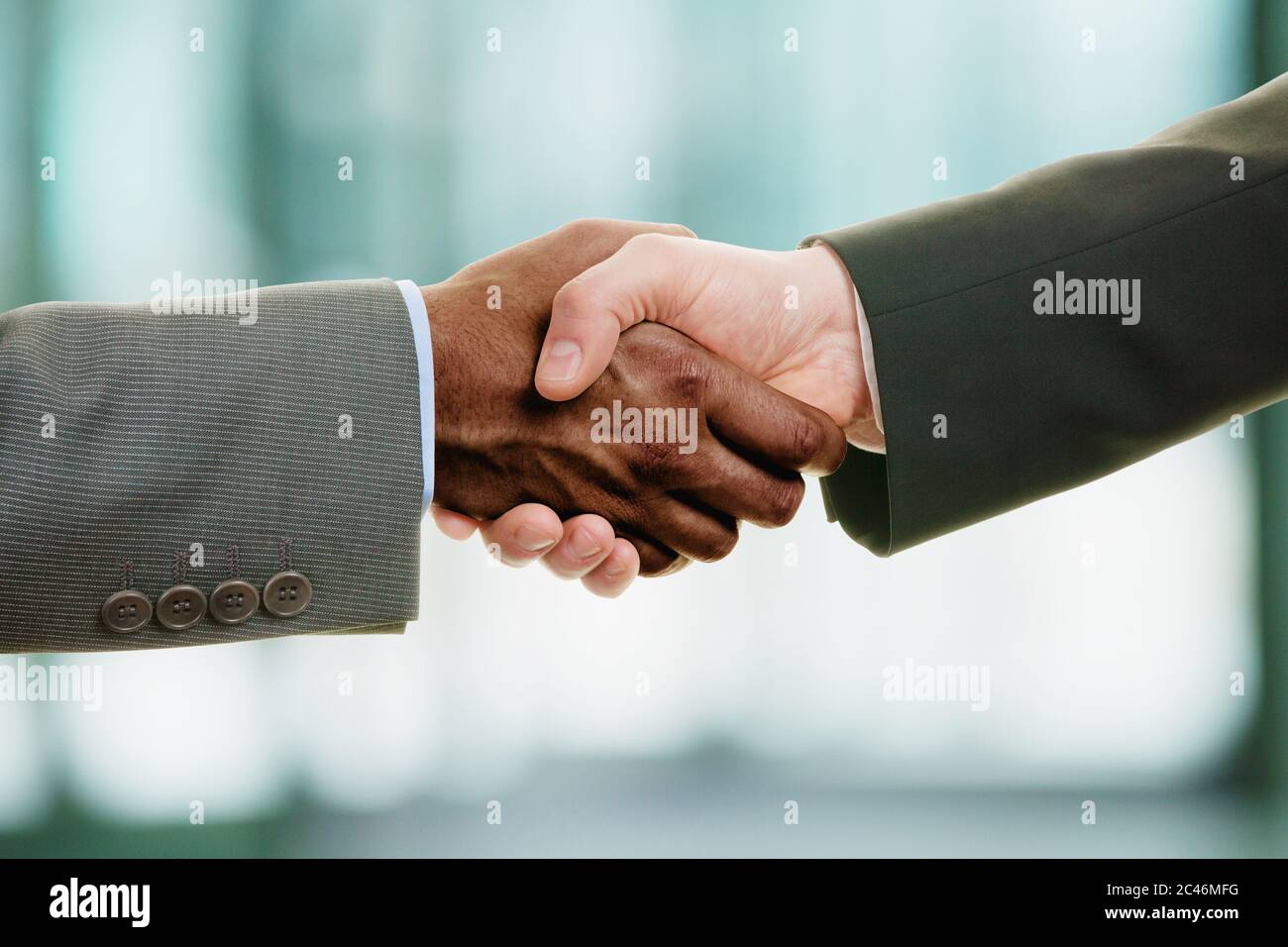 Interracial handshake on business background Stock Photo - Alamy