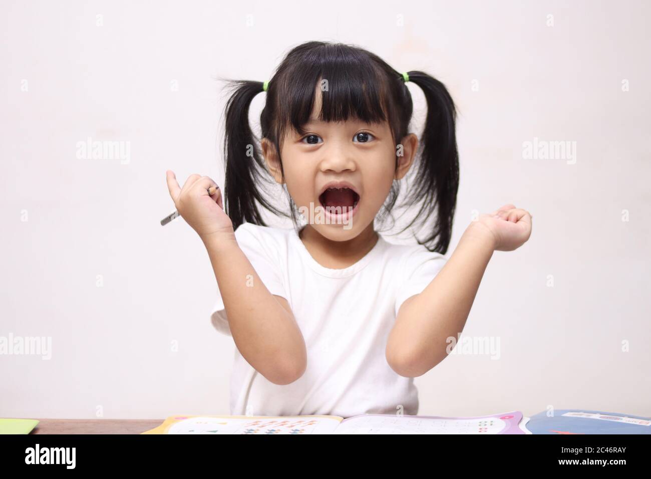 Cute adorable little Asian baby girl rising her hands up, looking at ...