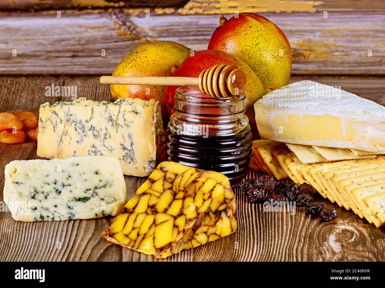 Different types of cheese with jar of honey on wooden background Stock ...
