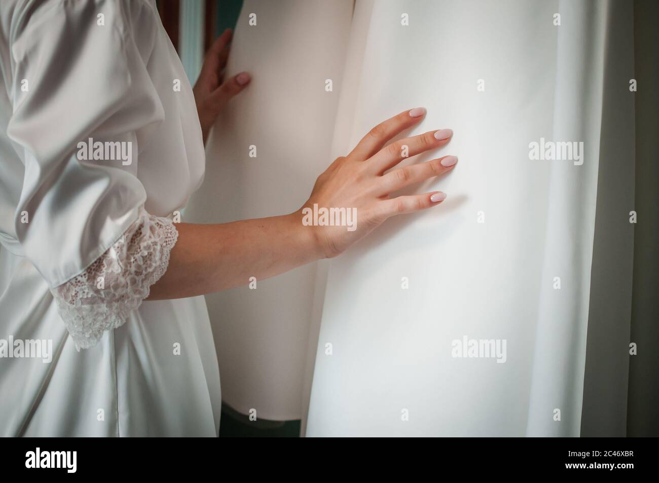 Bride puts hand on wedding dress Stock Photo - Alamy