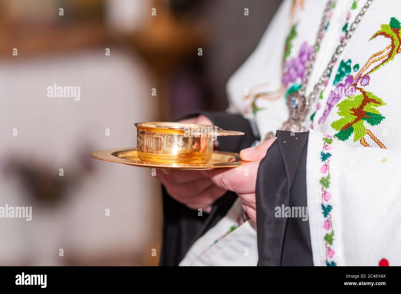 Priest holding gold cup with wine in the hands Stock Photo - Alamy