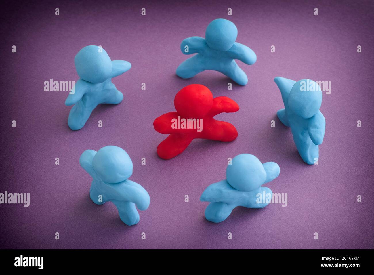 Blue plasticine people surrounding red plasticine person. Stand out ...