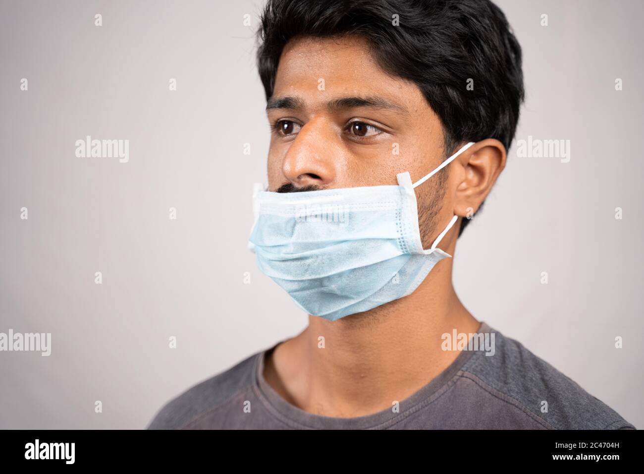young man wearing medical mask below nose - concept showing of improper ...