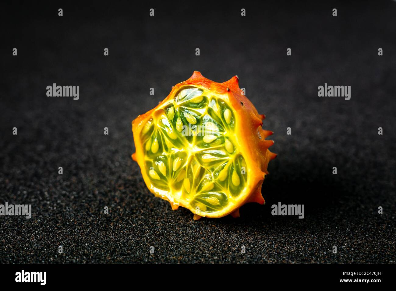 Kiwano fruit cut in half on dark grey background Stock Photo - Alamy