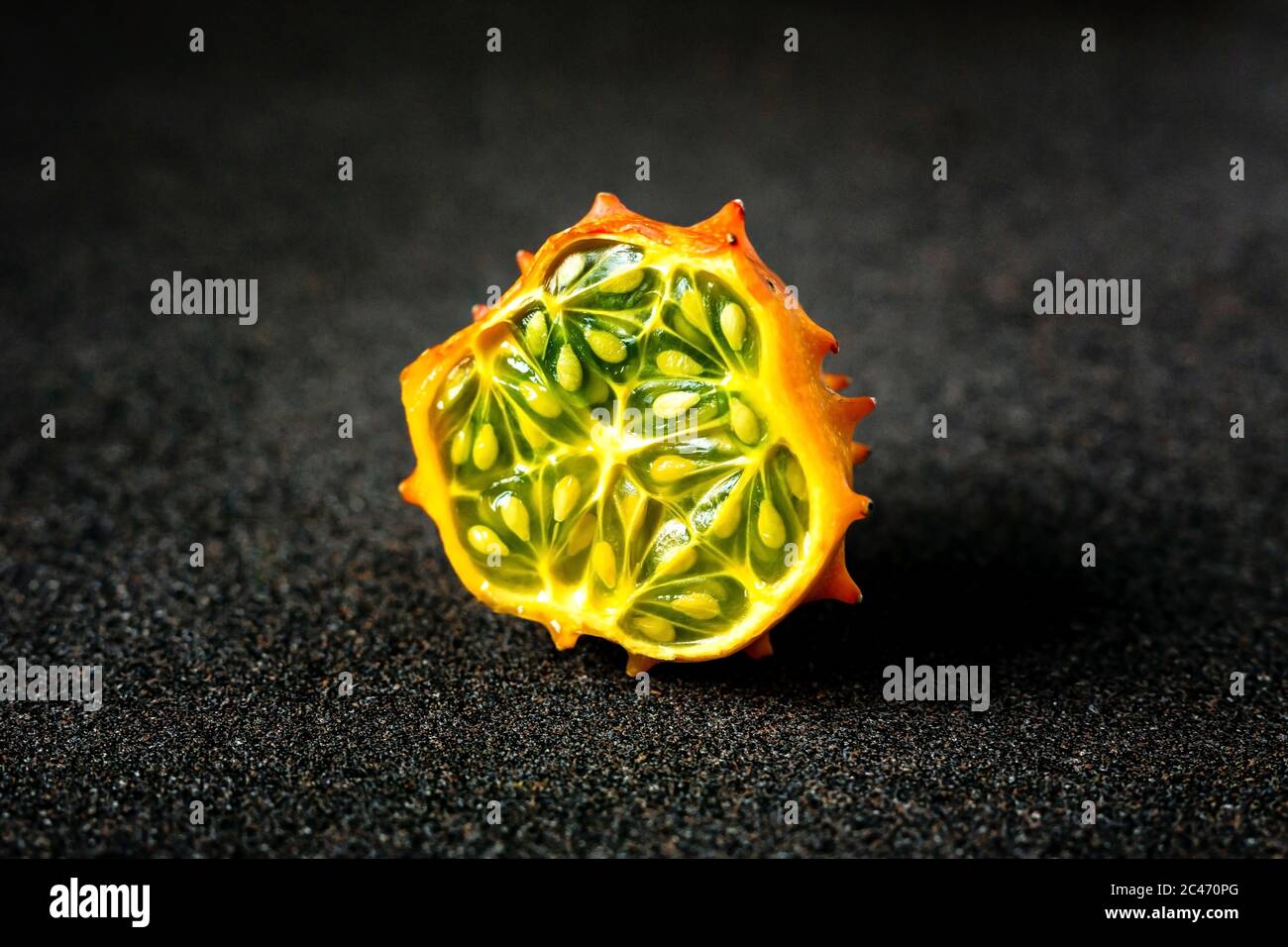 Kiwano fruit cut in half on dark grey background Stock Photo - Alamy