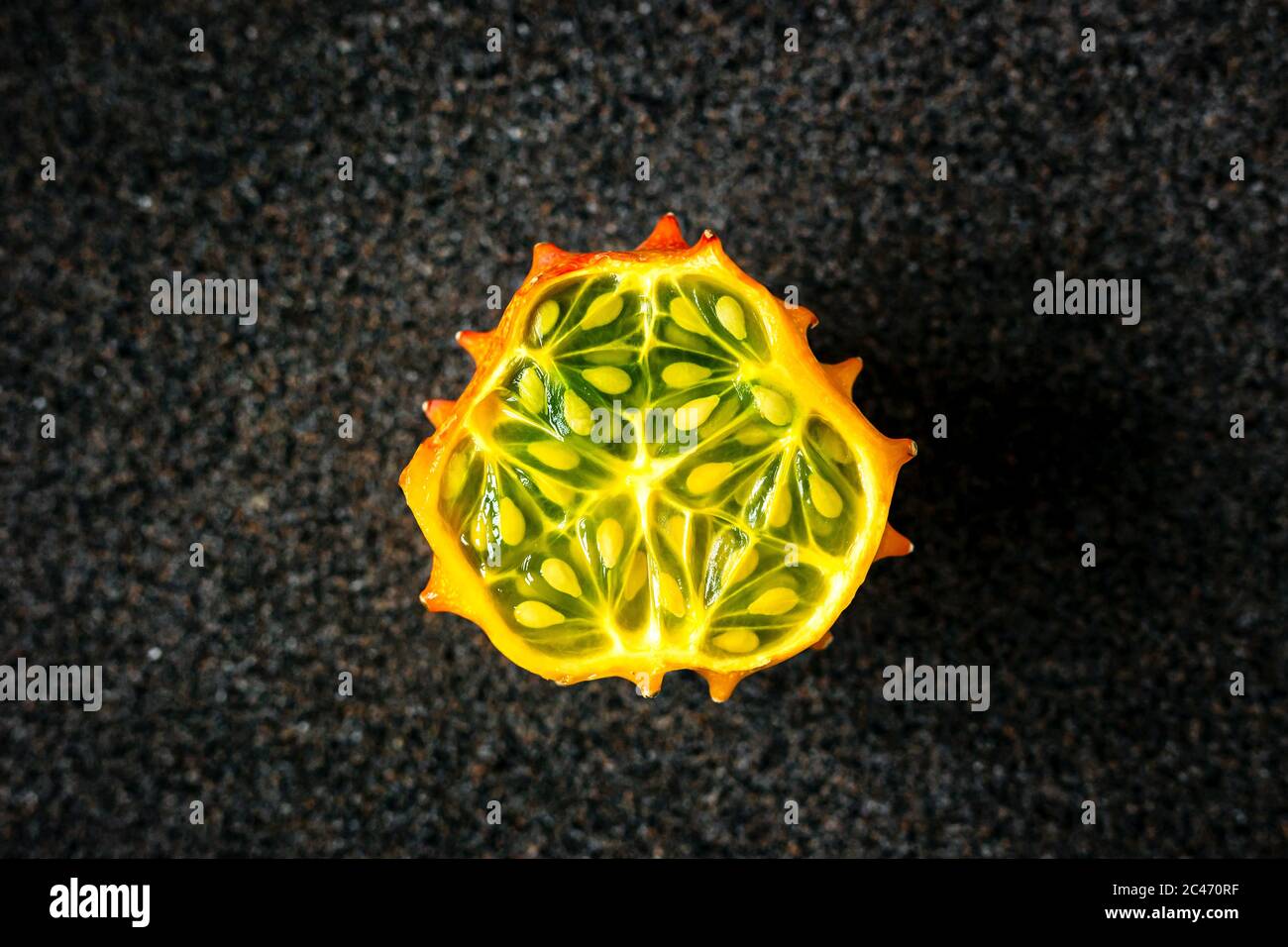 Kiwano fruit cut in half on dark grey background Stock Photo - Alamy