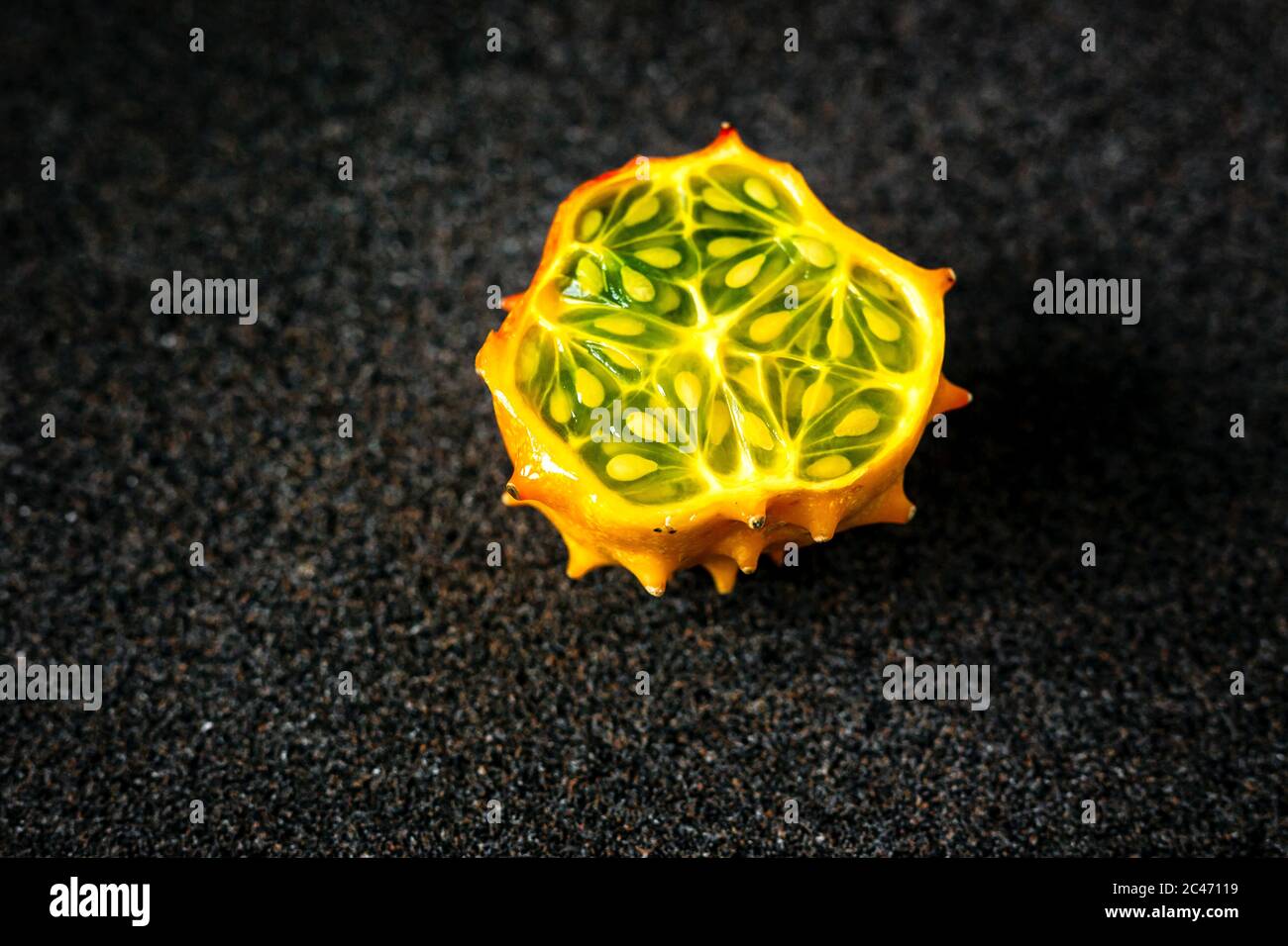 Kiwano fruit cut in half on dark grey background Stock Photo - Alamy