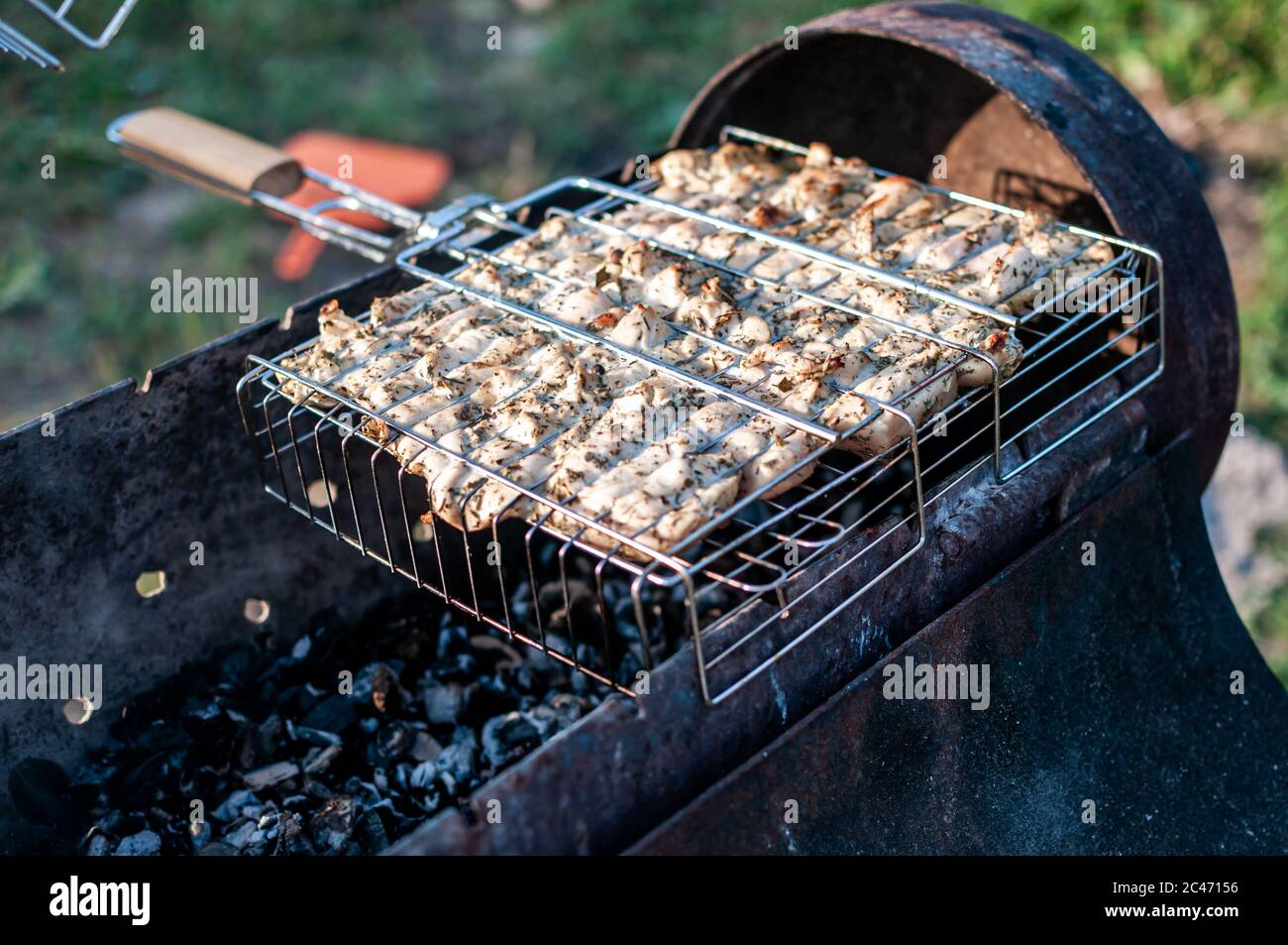 cooking raw meat in a grid on the barbeque grill Stock Photo - Alamy