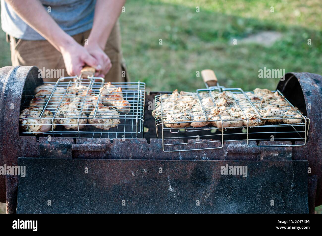 cooking raw meat in a grid on the barbeque grill Stock Photo - Alamy