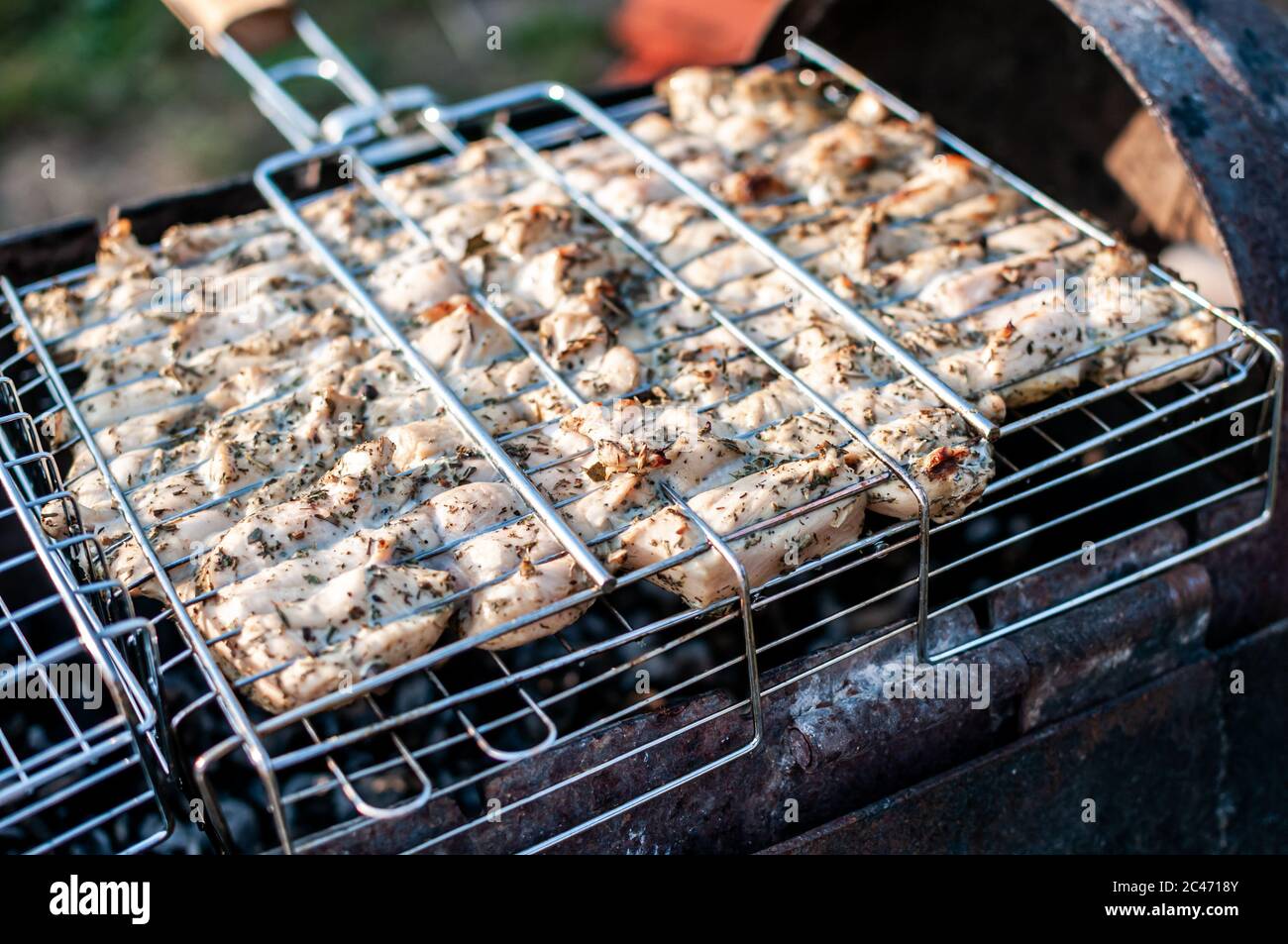 cooking raw meat in a grid on the barbeque grill Stock Photo - Alamy