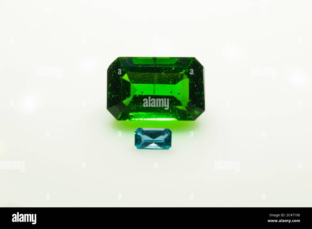 Natural green moldavite and blue grandidierite on the white background ...