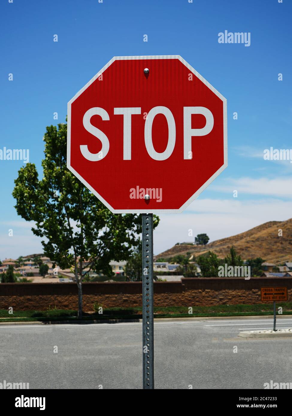 An octogonal red stop sign with street and trees Stock Photo - Alamy