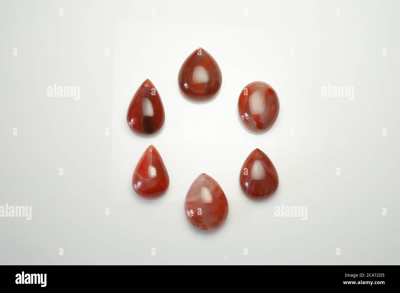 Red agate cabochon on the white background Stock Photo - Alamy