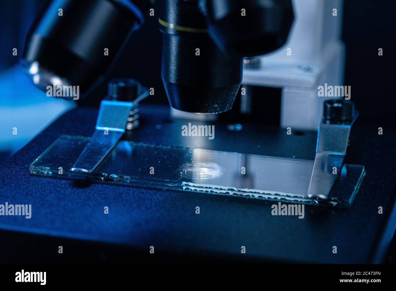 Microscope with lenses close up against dark background Stock Photo - Alamy