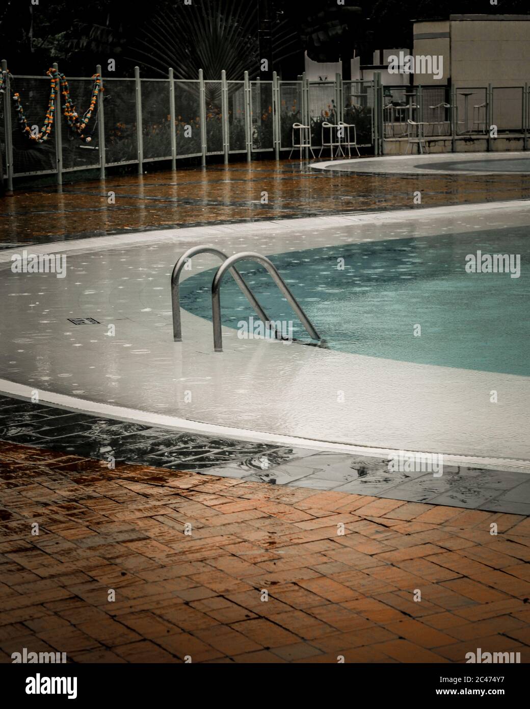 Vertical shot of an outdoor pool surrounded by orange bricks on a ...
