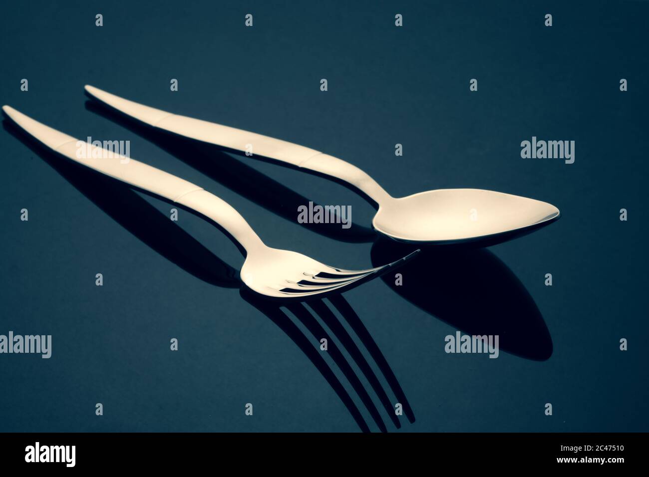 Metal spoon and fork on table Stock Photo - Alamy