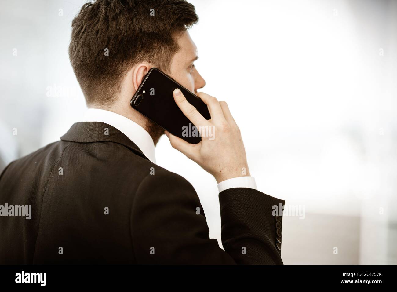 Business concept. Young businessman back at the office standing and ...
