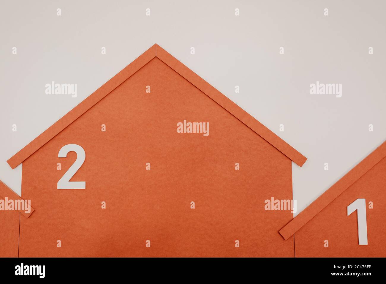 Close up shot of orange colored carton houses numbered on a grey ...