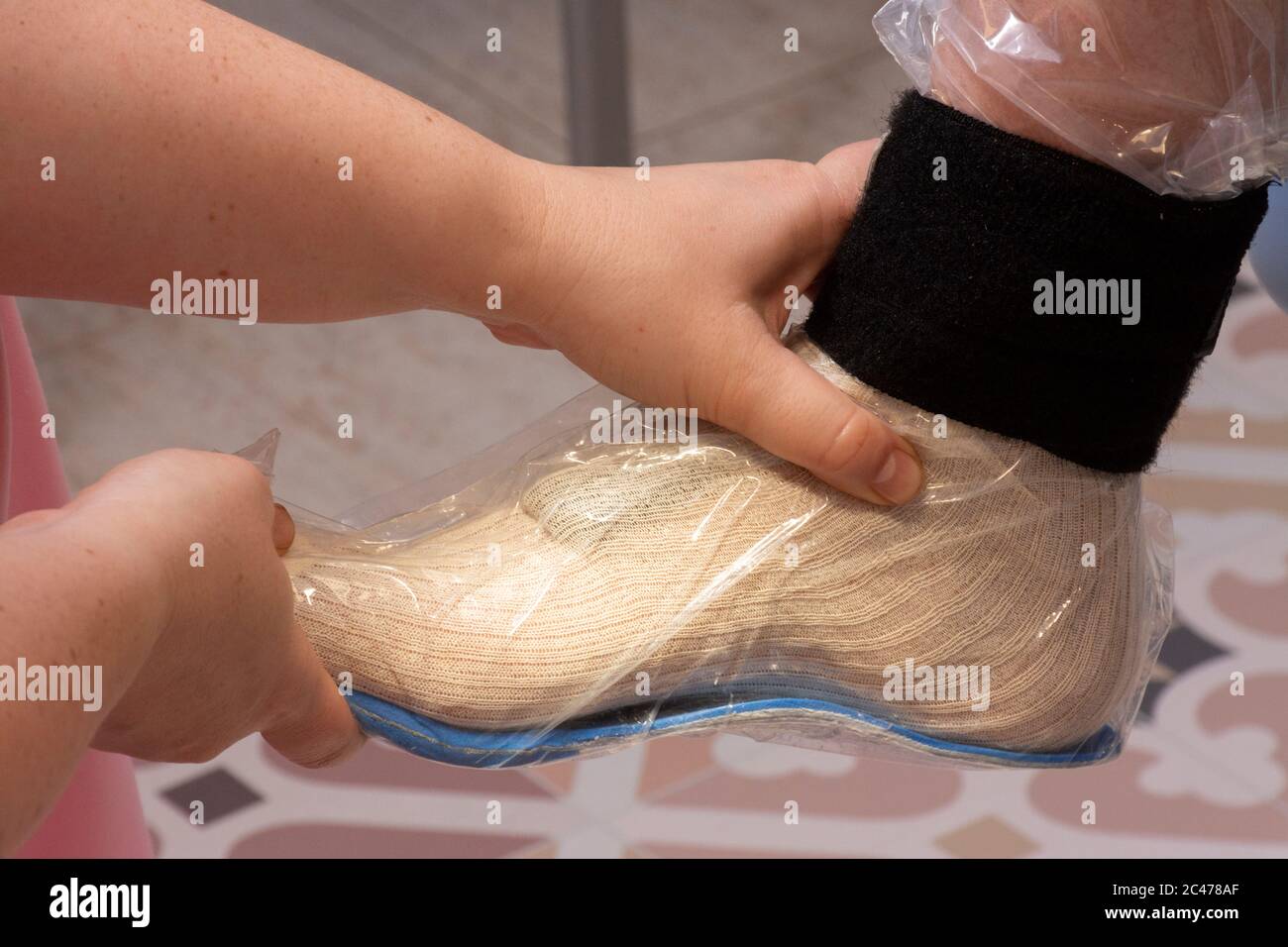 An unrecognizable female podiatrist pressing the foot and adjusting the ...
