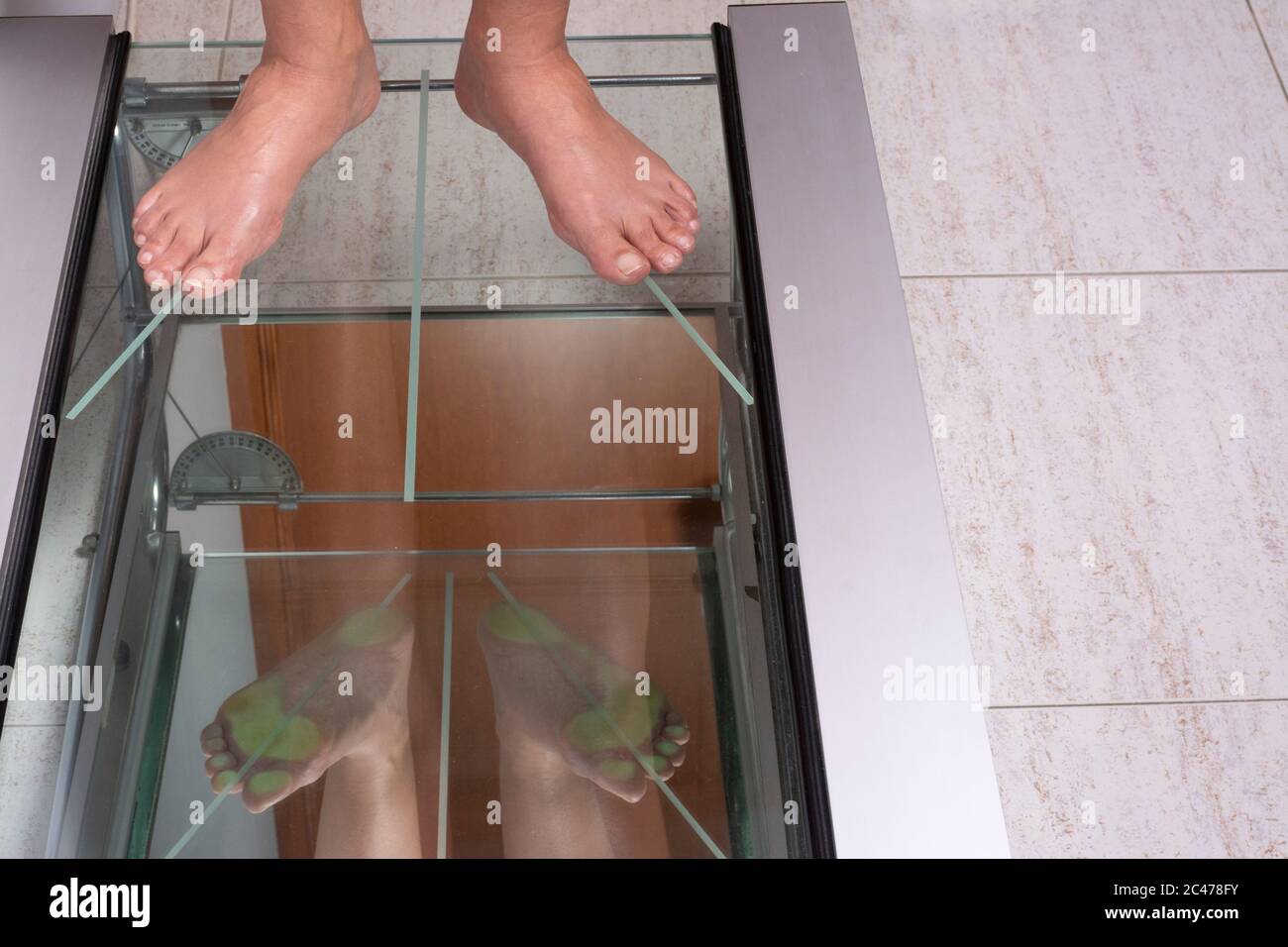 Feet of a woman on a pedoscope for the biomechanical study of the tread ...